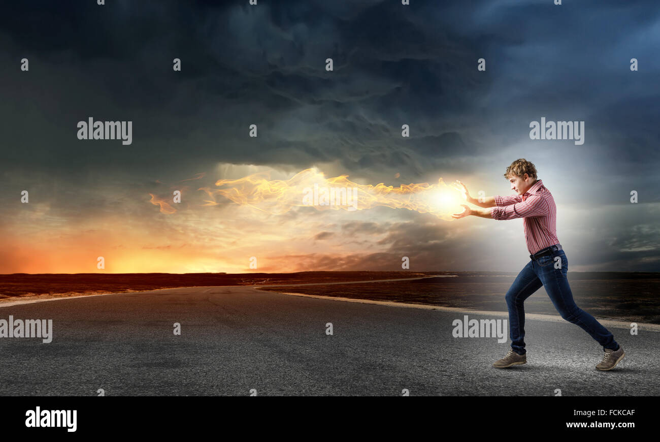 Young man in casual throwing magic fire balls Stock Photo - Alamy
