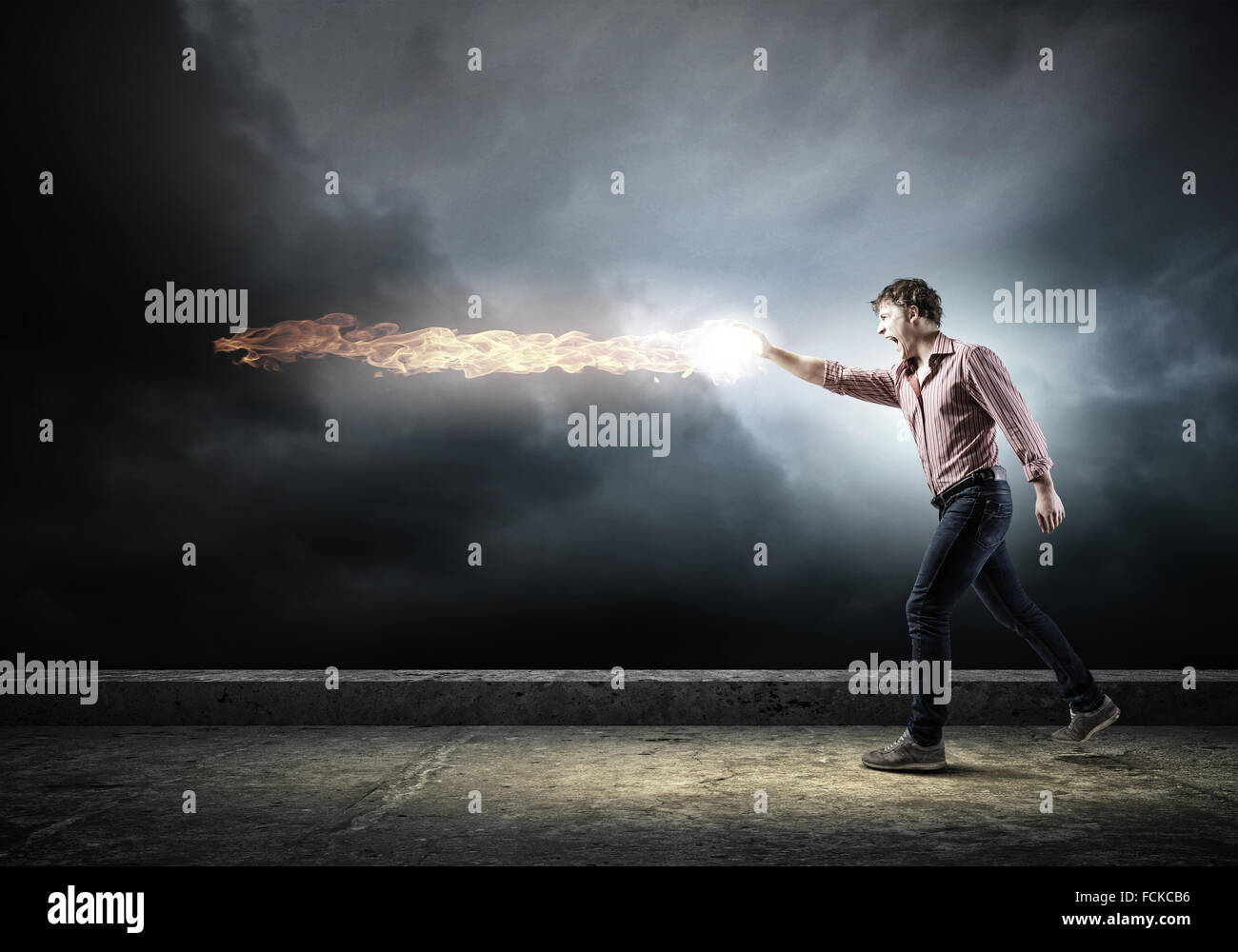 Young man in casual throwing magic fire balls Stock Photo - Alamy