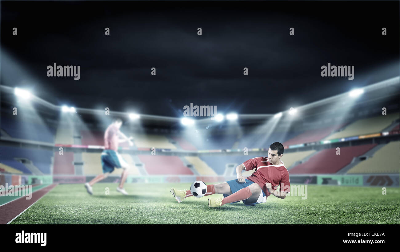 Two football player fighting for ball at stadium Stock Photo - Alamy