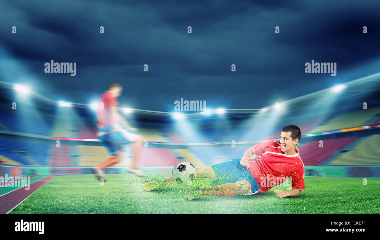 Two football player fighting for ball at stadium Stock Photo - Alamy