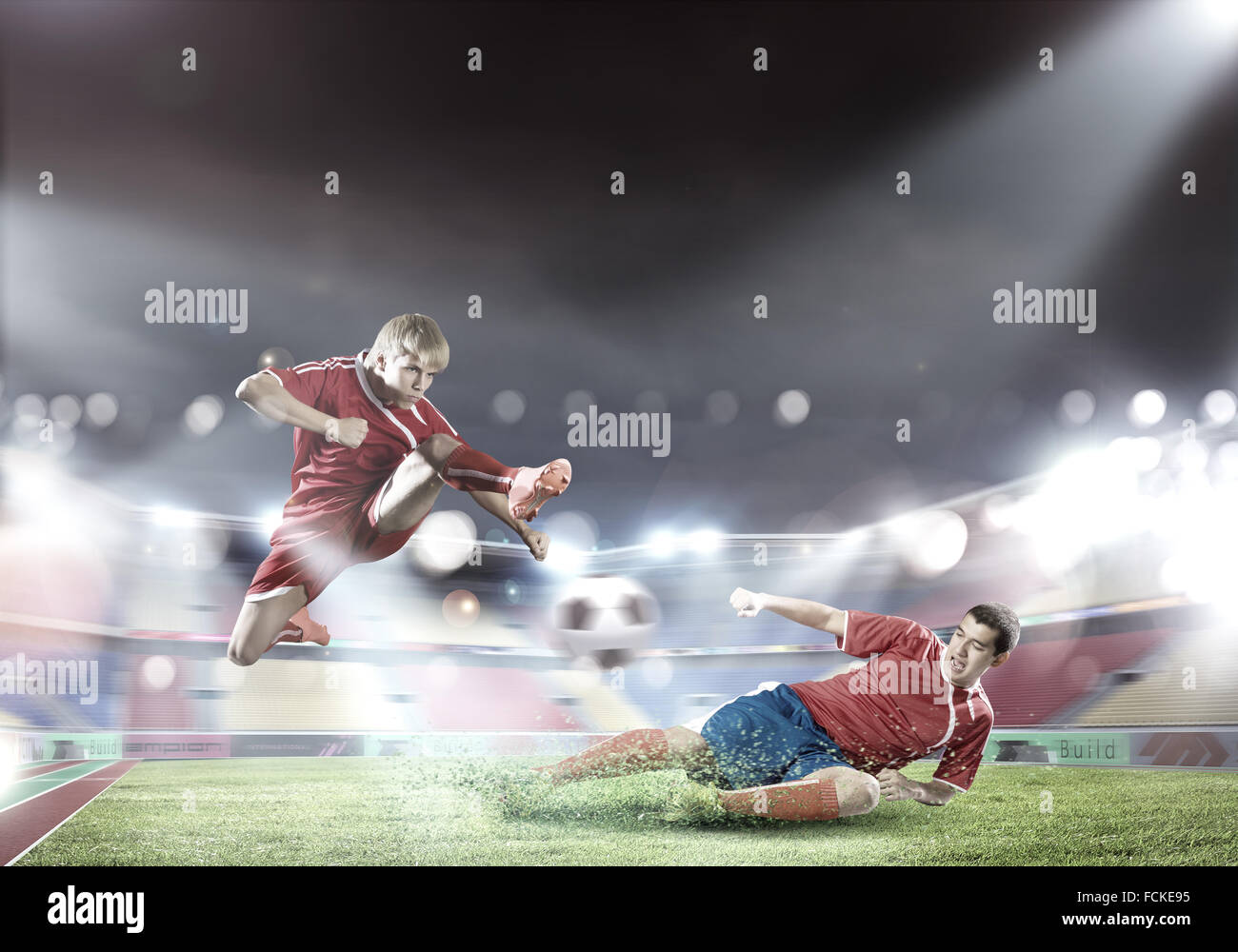 Two football player fighting for ball at stadium Stock Photo - Alamy