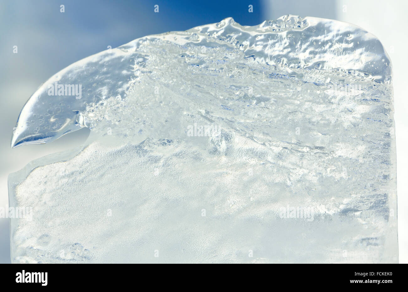 Melting transparent top piece of ice lit by the spring sunshine closeup ...