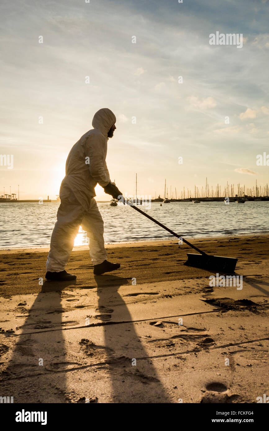 Cleaning city beach near container port following oil/fuel spill Stock ...