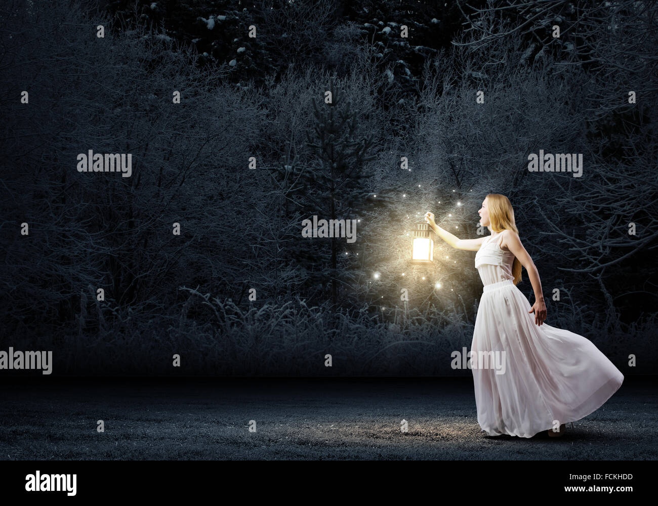 Young woman with lantern walking in dark forest Stock Photo - Alamy