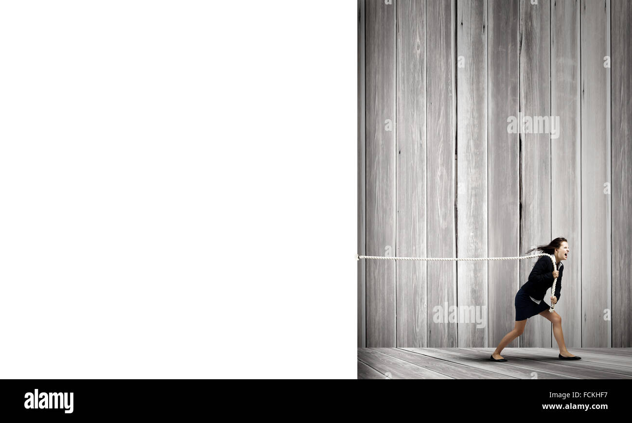 Young determined businesswoman pulling white blank banner with rope ...