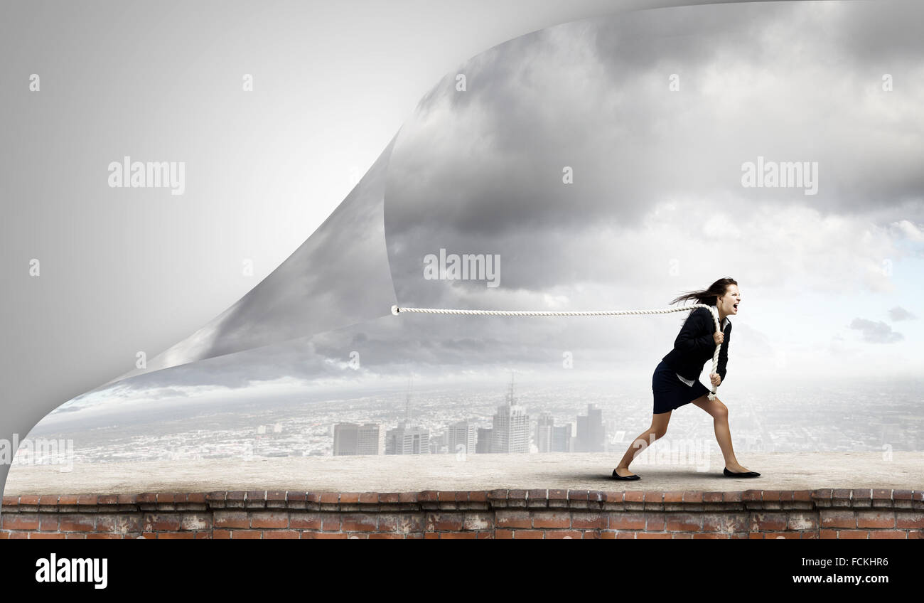 Young businesswoman pulling urban reality with rope Stock Photo - Alamy