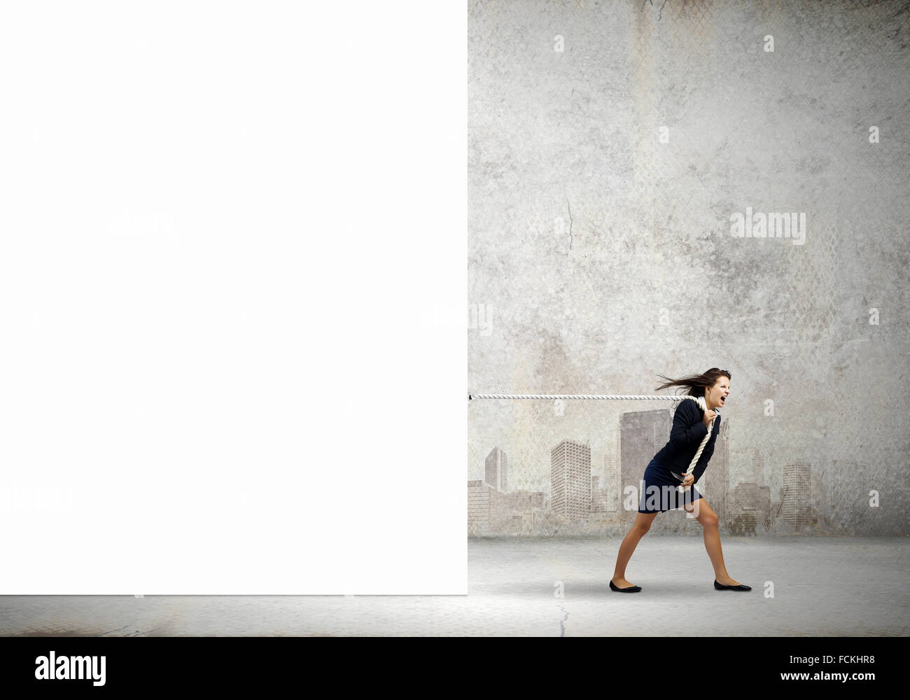 Young determined businesswoman pulling white blank banner with rope ...