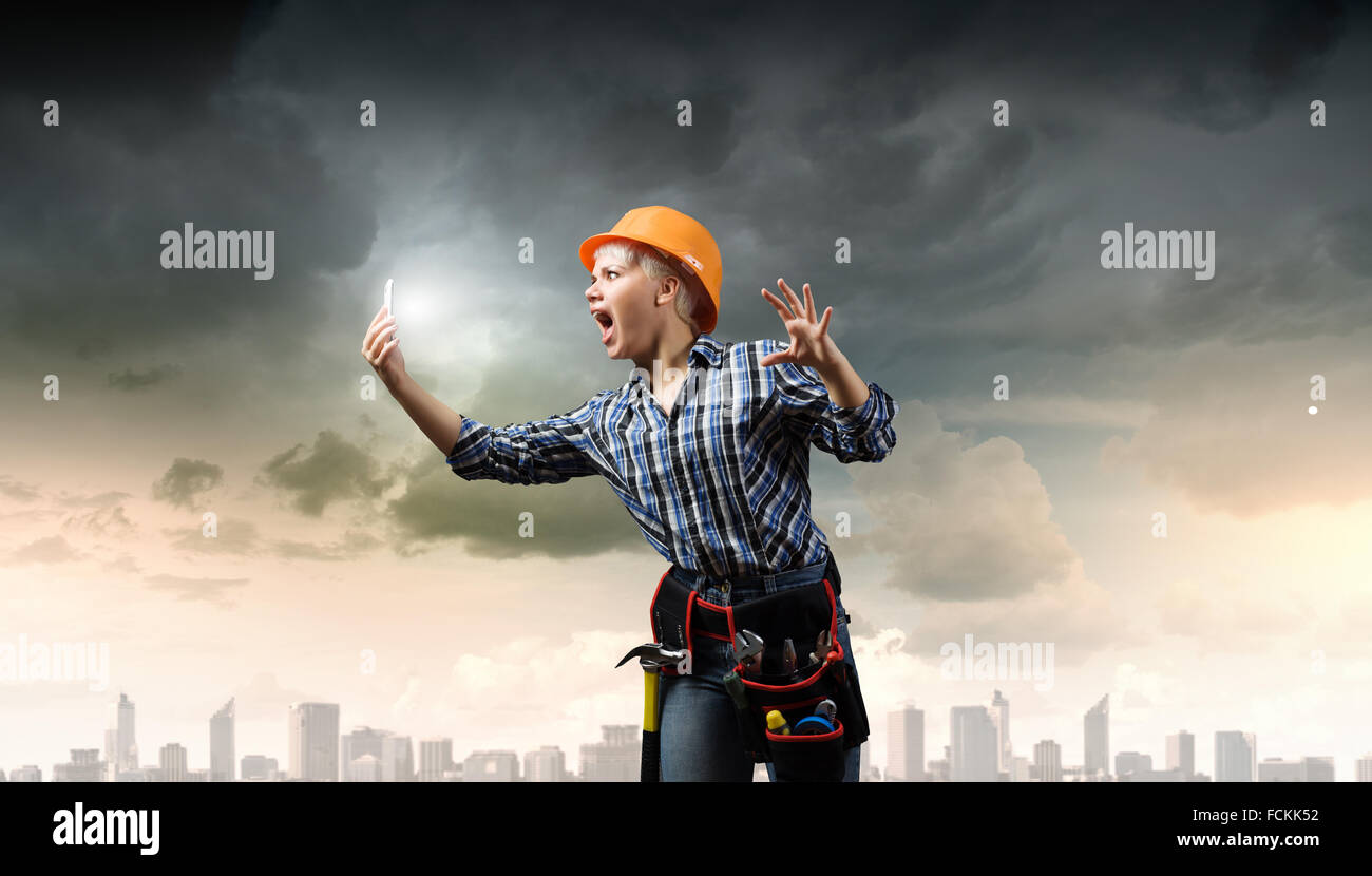 Young emotional woman mechanic screaming in mobile phone Stock Photo ...