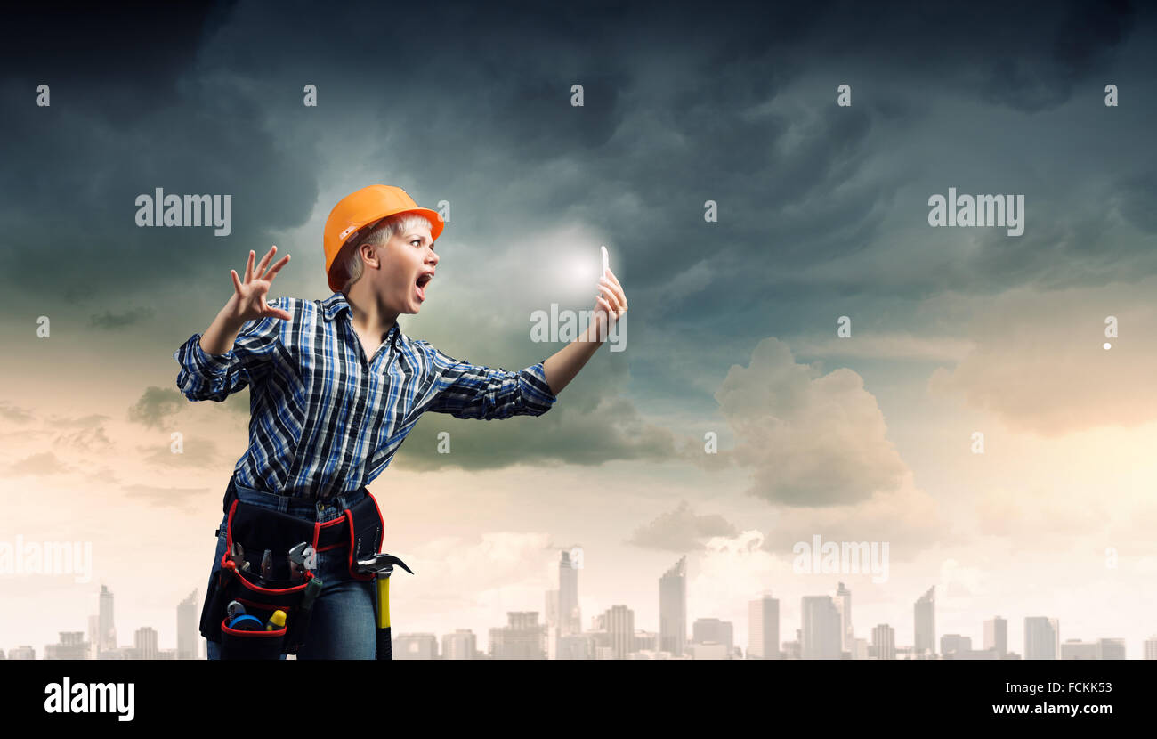 Young emotional woman mechanic screaming in mobile phone Stock Photo ...