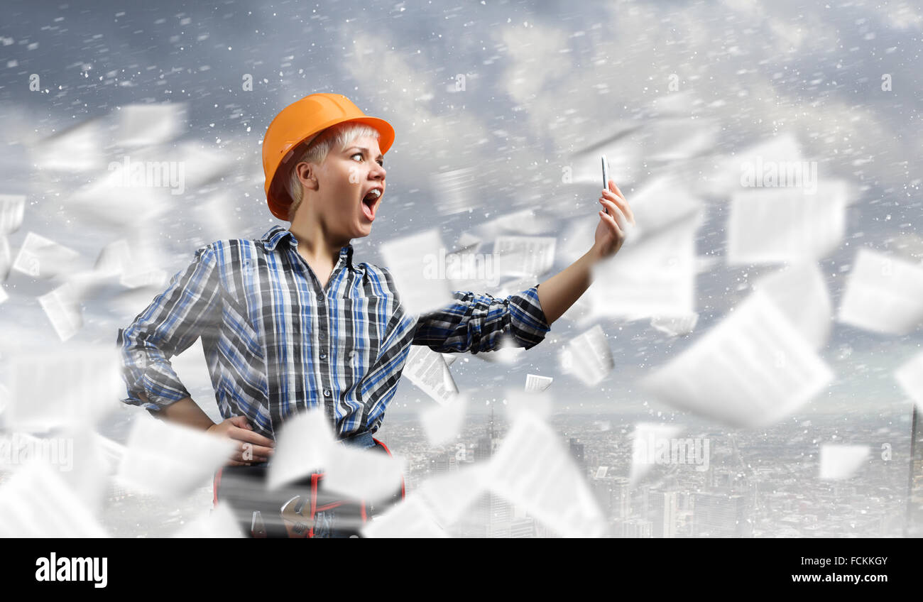 Young emotional woman mechanic screaming in mobile phone Stock Photo ...