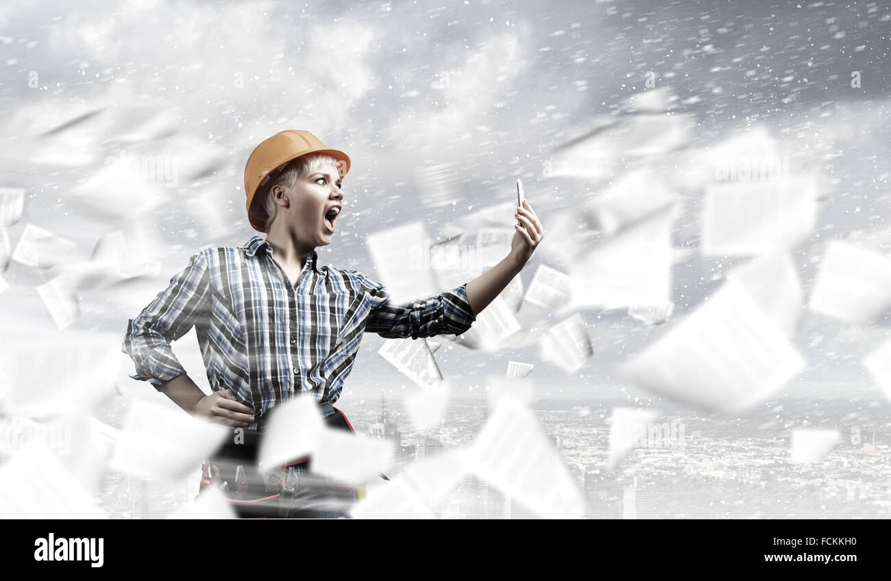 Young emotional woman mechanic screaming in mobile phone Stock Photo ...