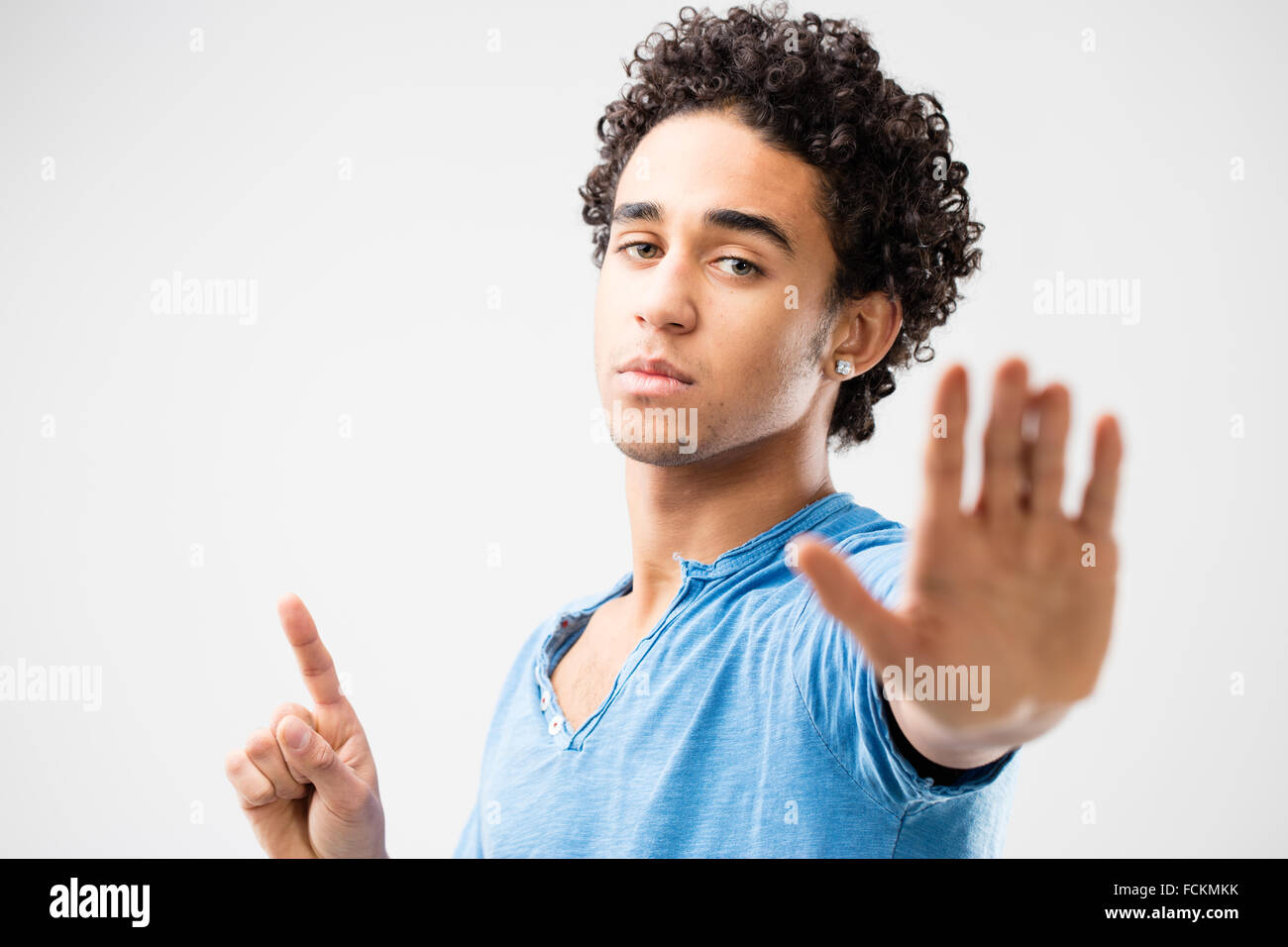 handsome young man stopping something with a hand and saying no with ...