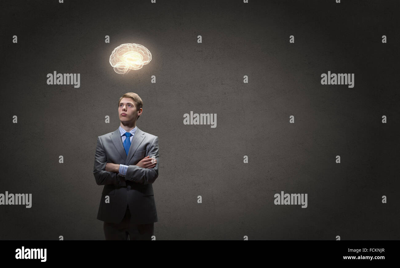 Young thoughtful businessman and human brain above his head Stock Photo ...
