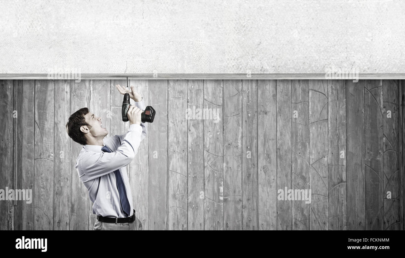 Young businessman using drill hi-res stock photography and images - Alamy