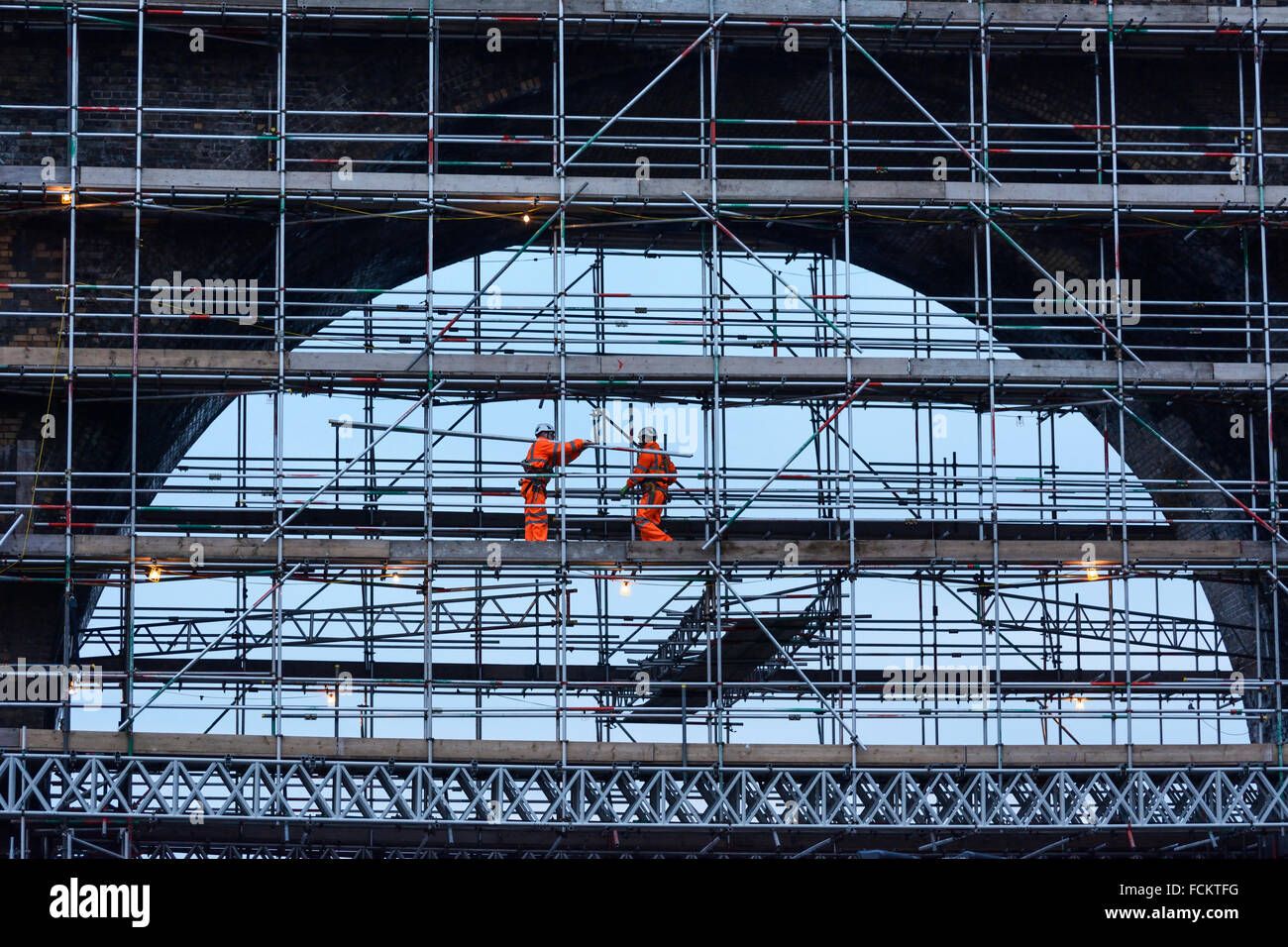 Railway workers on scaffolding carrying out maintainance work on the ...
