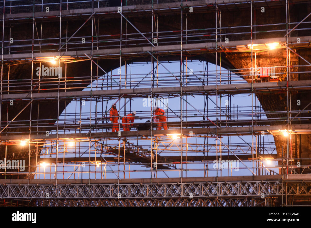 Railway workers on scaffolding carrying out maintainance work on the ...
