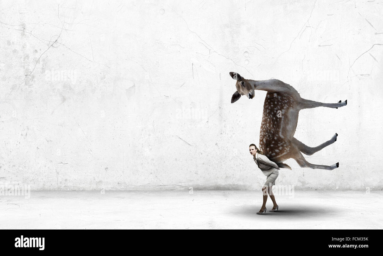 Businesswoman carrying big deer on her back Stock Photo - Alamy