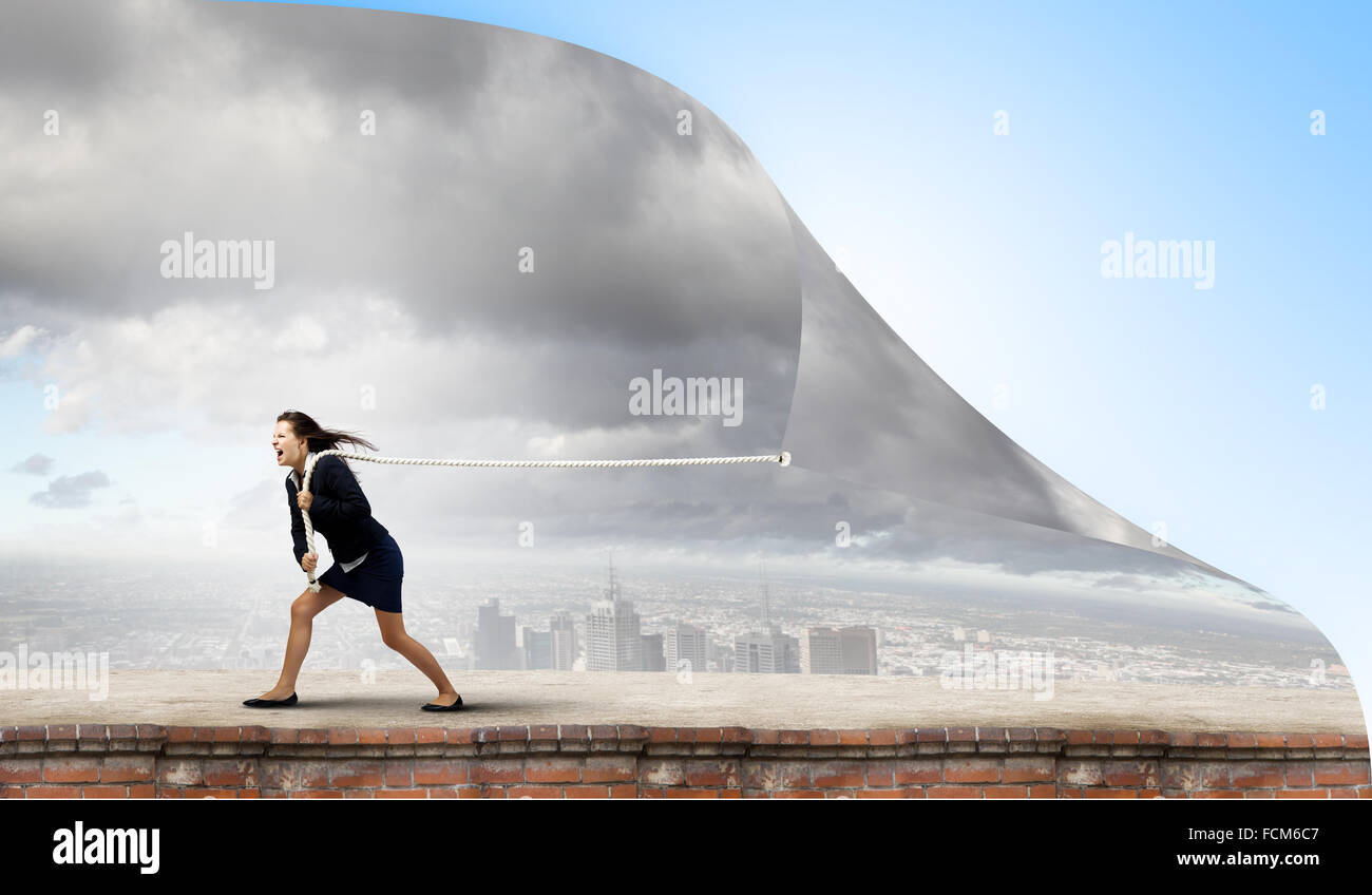 Young determined businesswoman pulling white blank banner with rope ...