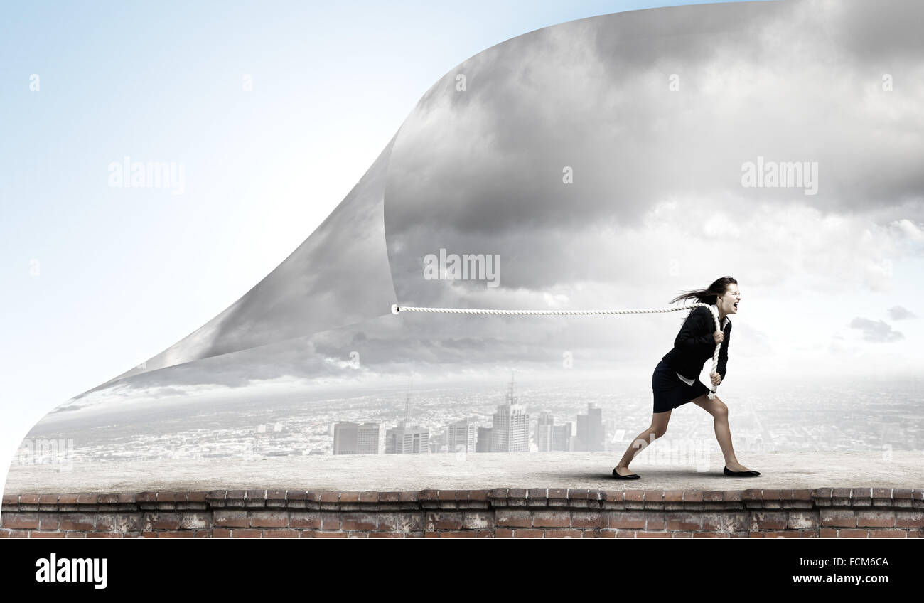 Young determined businesswoman pulling white blank banner with rope ...