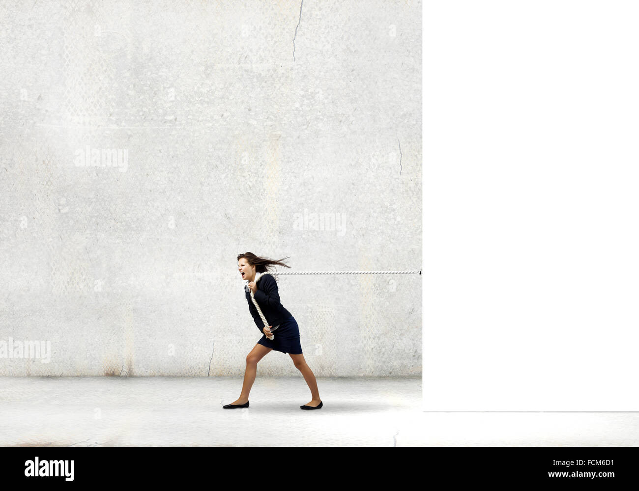 Young determined businesswoman pulling white blank banner with rope ...