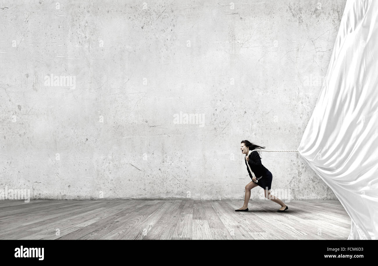 Young determined businesswoman pulling white blank banner with rope ...