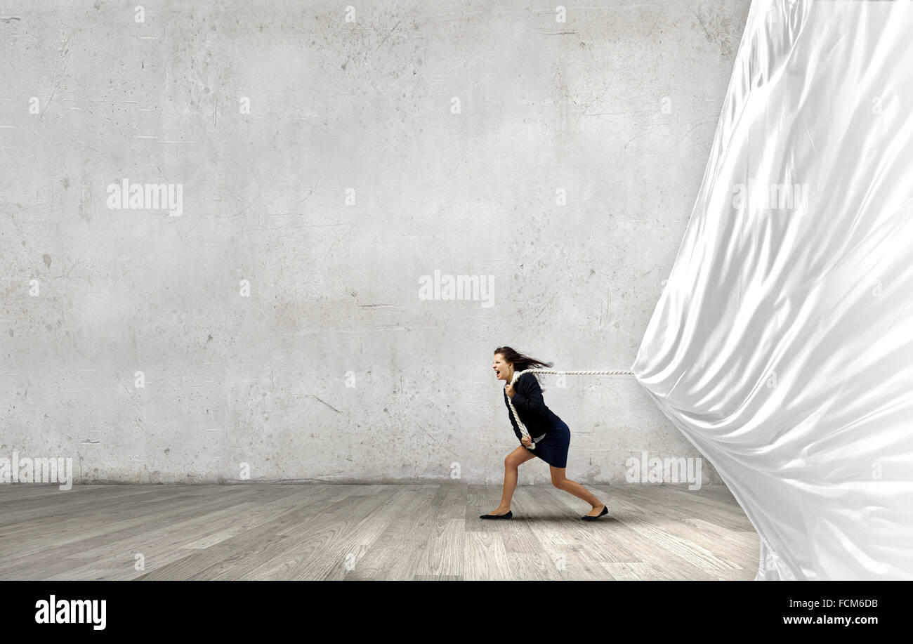 Young determined businesswoman pulling white blank banner with rope ...