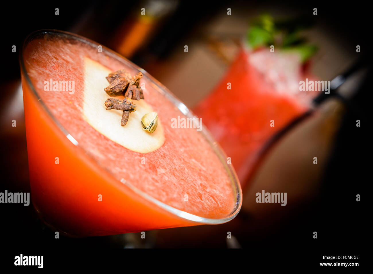 Cocktail with garnish in a bar surrounding Stock Photo - Alamy