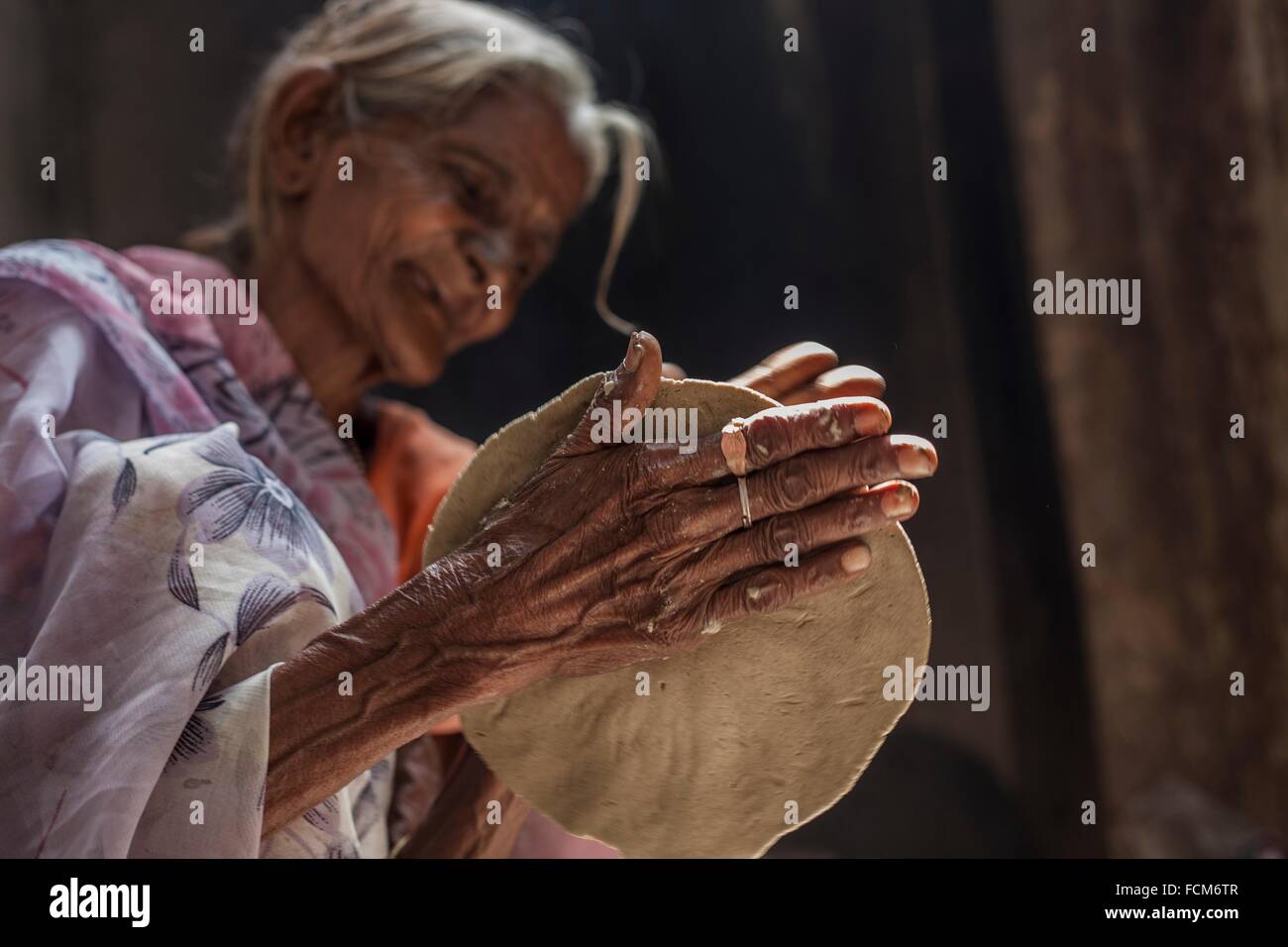 Elderly woman preparing food for the family in a slum in India Stock ...