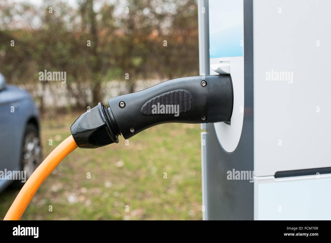 Charging station with plug, cable and car Stock Photo - Alamy