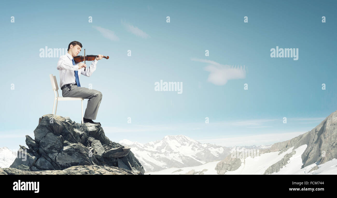 Young businessman sitting in chair and playing violin Stock Photo - Alamy