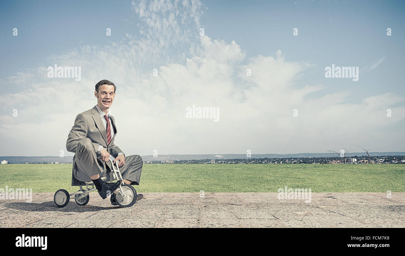 Young handsome businessman riding three wheeled bicycle Stock Photo - Alamy
