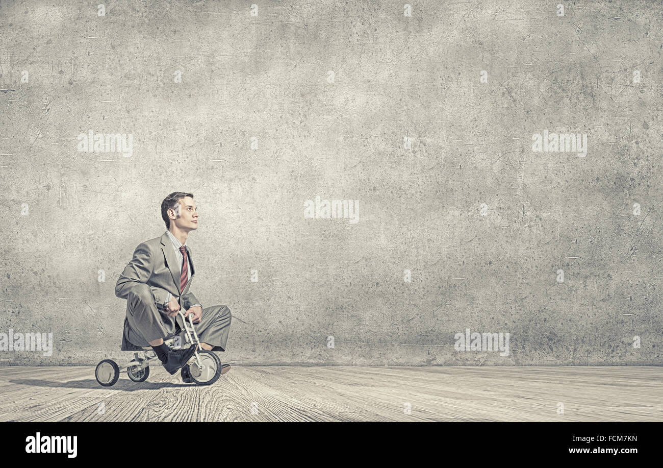 Young handsome businessman riding three wheeled bicycle Stock Photo - Alamy