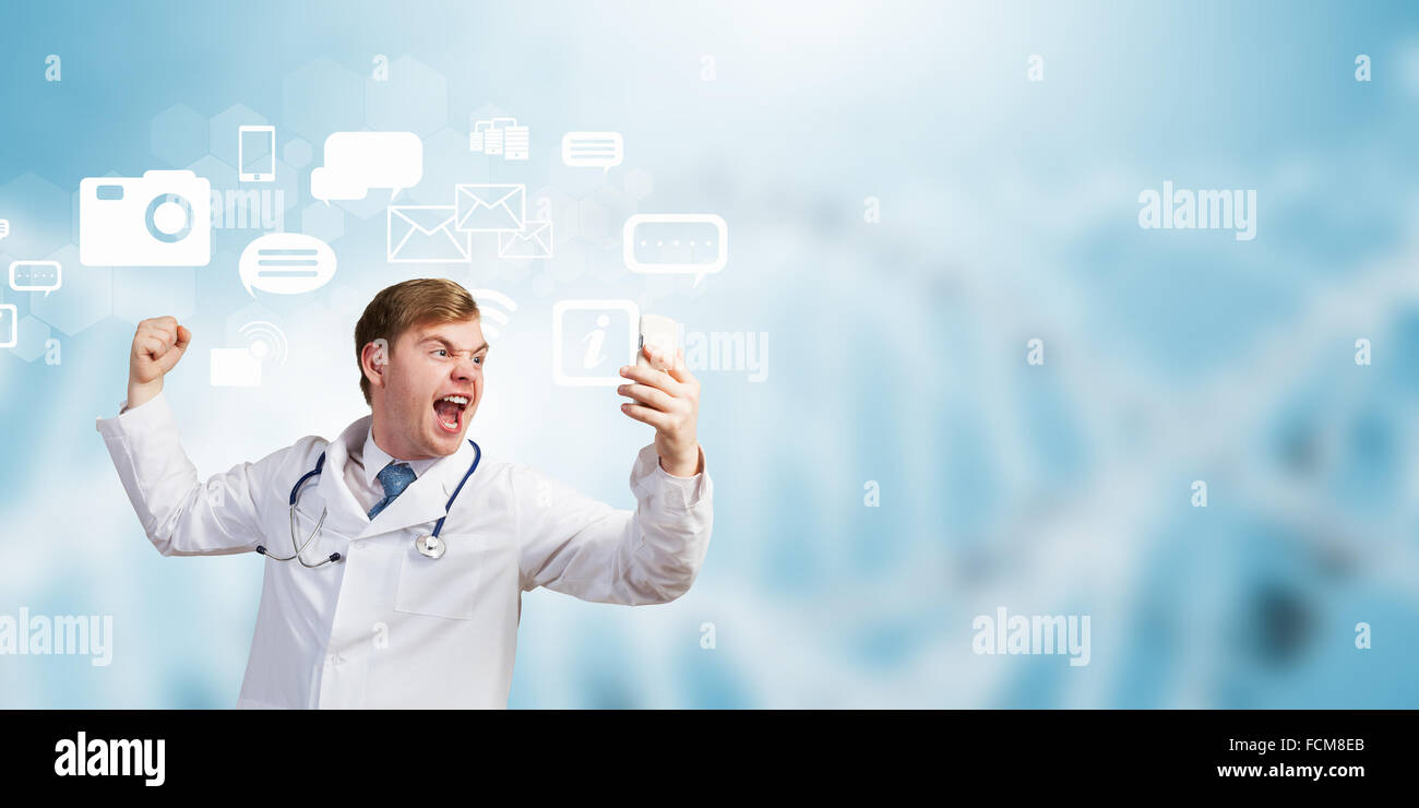Young male doctor screaming in mobile phone emotionally Stock Photo - Alamy