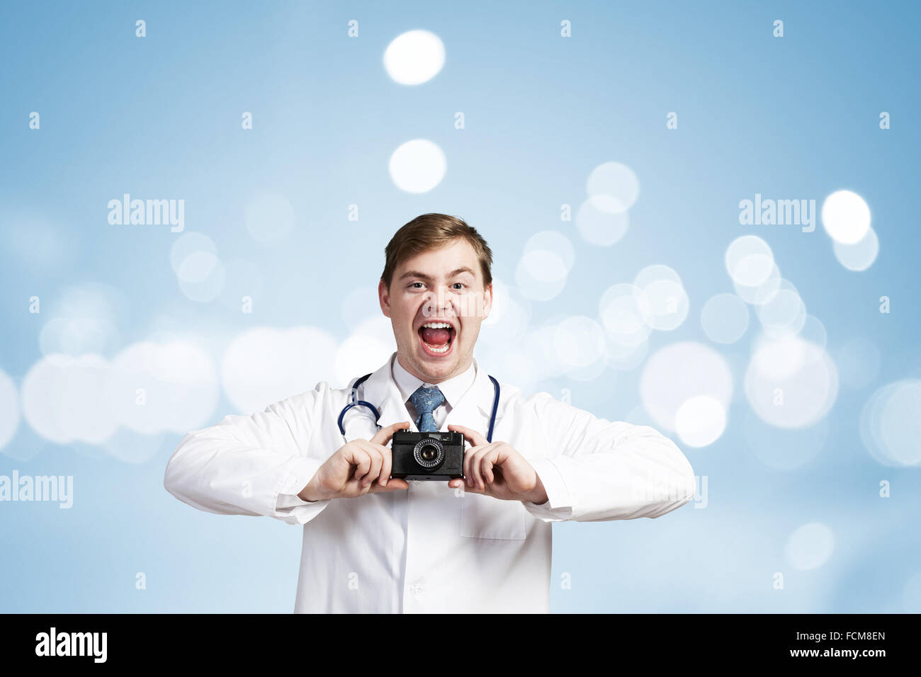 Funny young doctor with photo camera screaming emotionally Stock Photo ...