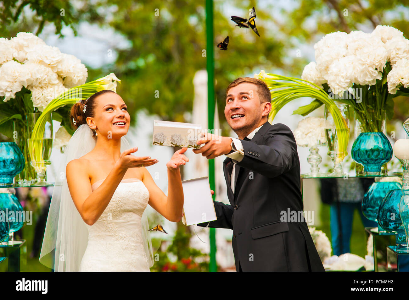 The newlyweds are looking on the flying butterfly Stock Photo - Alamy