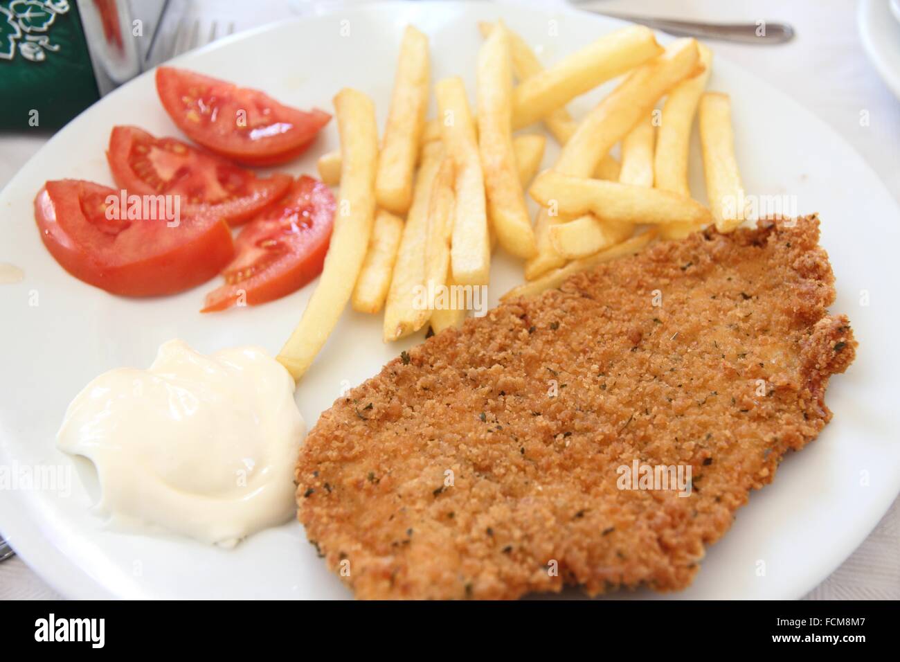 Breaded chicken fillet and fries, fresh tomato and mayonnaise Stock ...