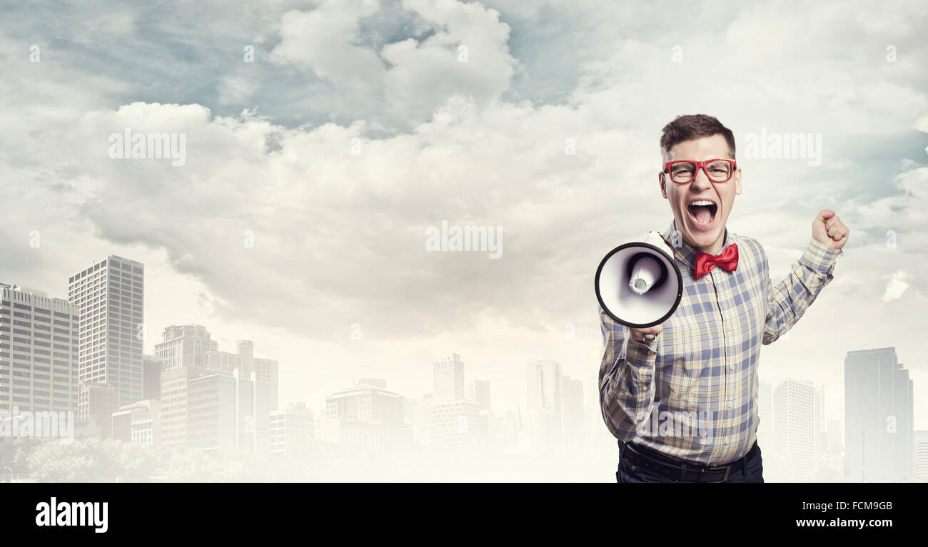 Young funny man screaming emotionally in megaphone Stock Photo - Alamy