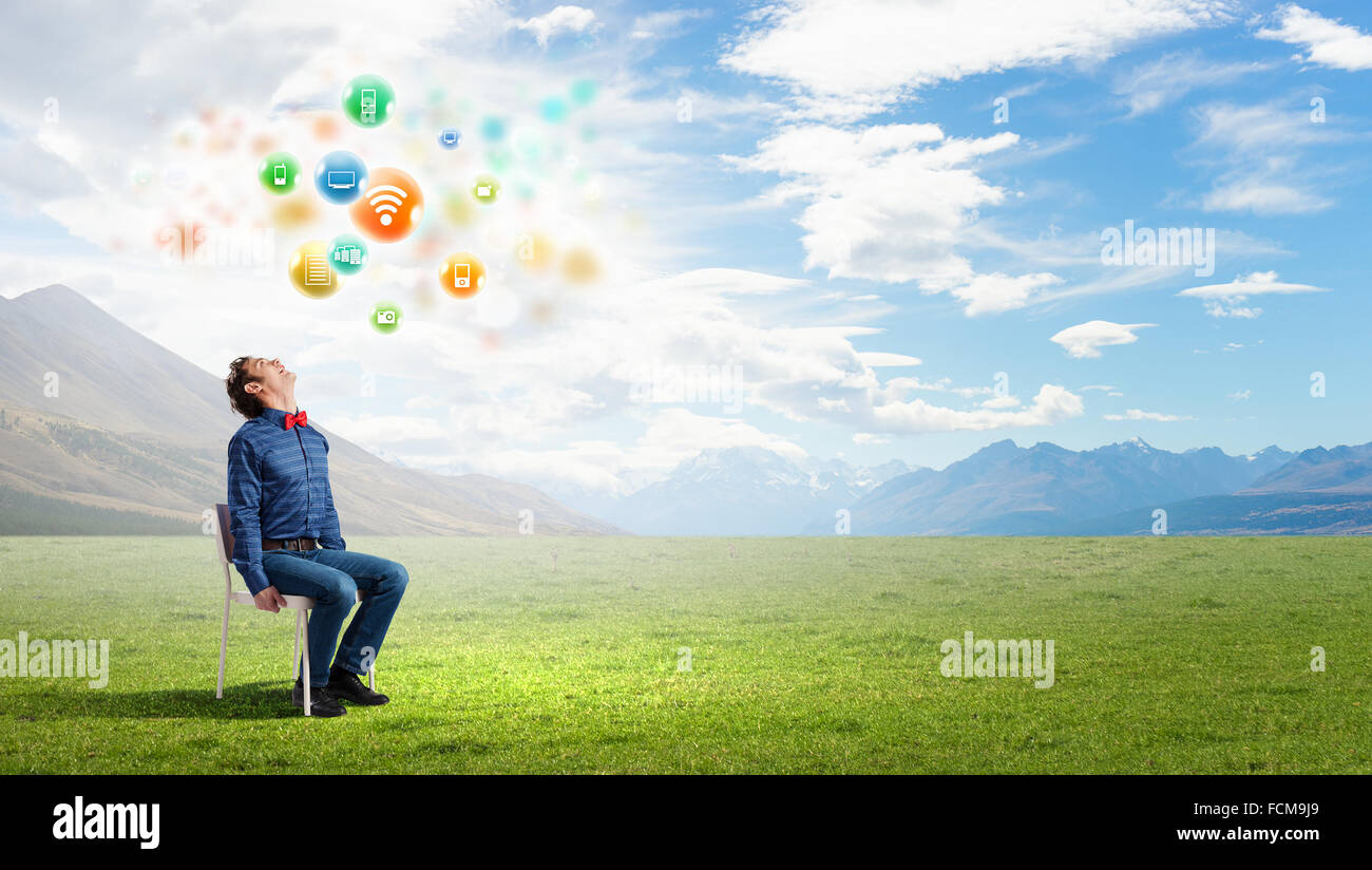 Young funny guy sitting in chair and looking upwards Stock Photo - Alamy