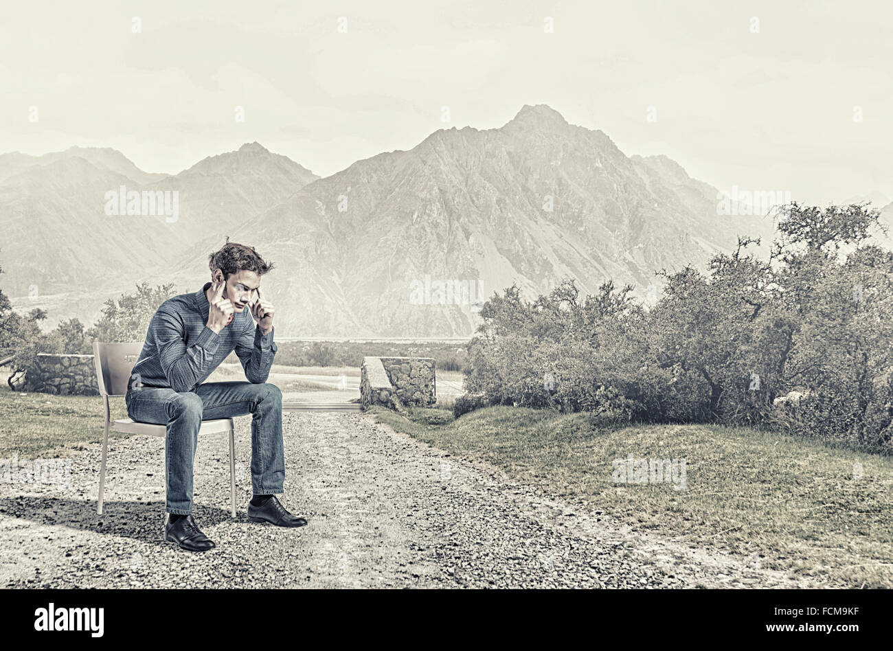 Troubled young man sitting in chair outdoors Stock Photo - Alamy