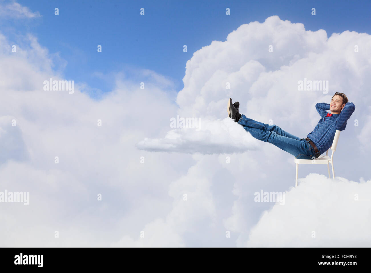Young man sitting in chair with legs up and relaxing Stock Photo - Alamy