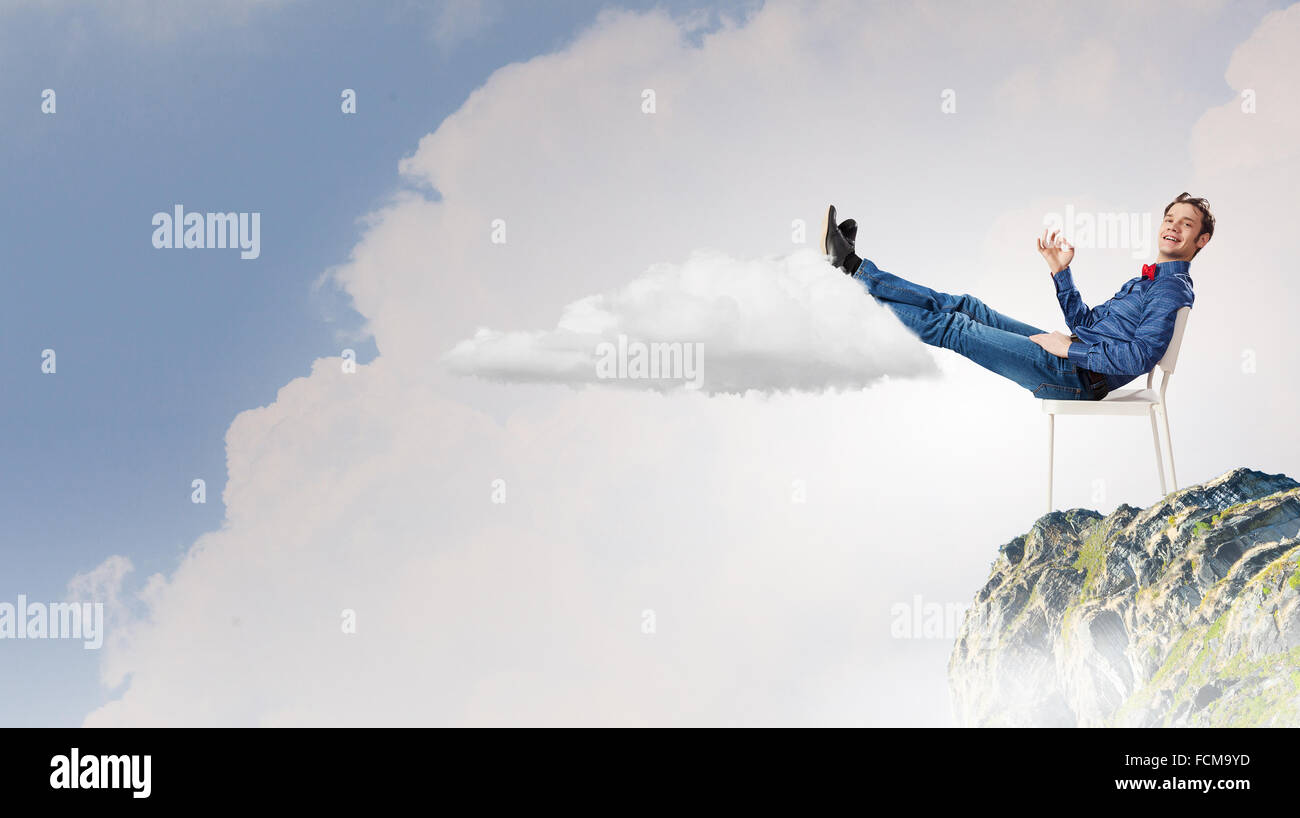 Young man sitting in chair with legs up and relaxing Stock Photo - Alamy