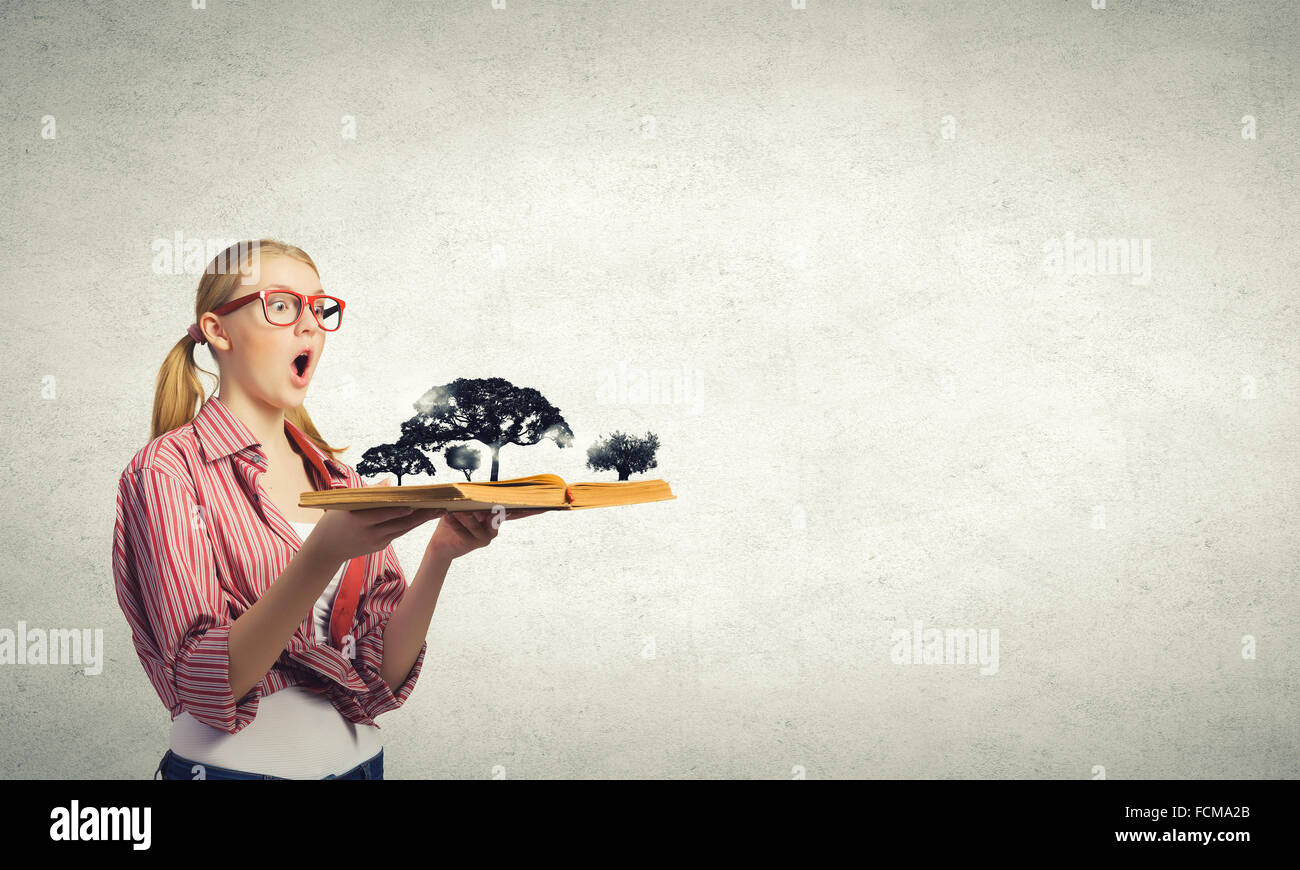 Young funny girl with opened book in hands Stock Photo - Alamy