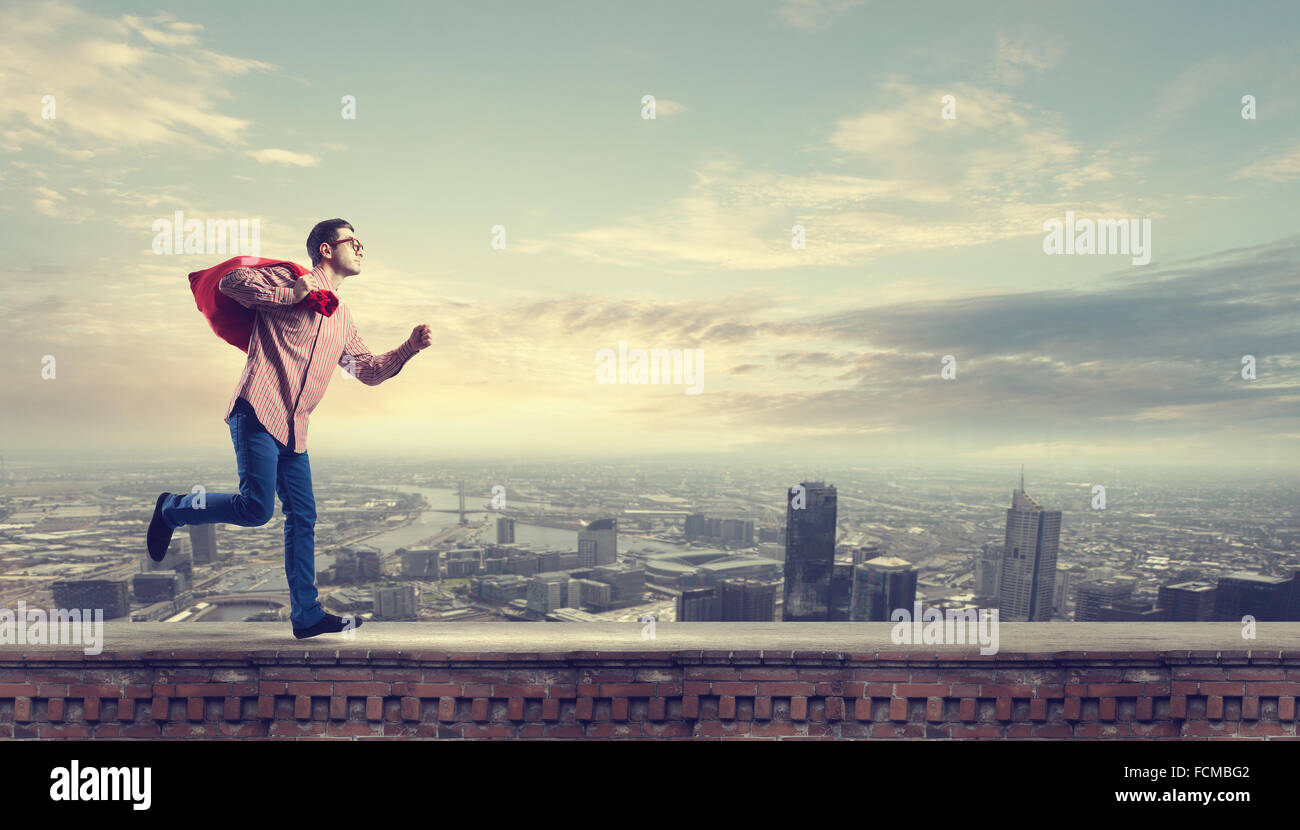 Young man in casual carrying heavy red bag Stock Photo - Alamy