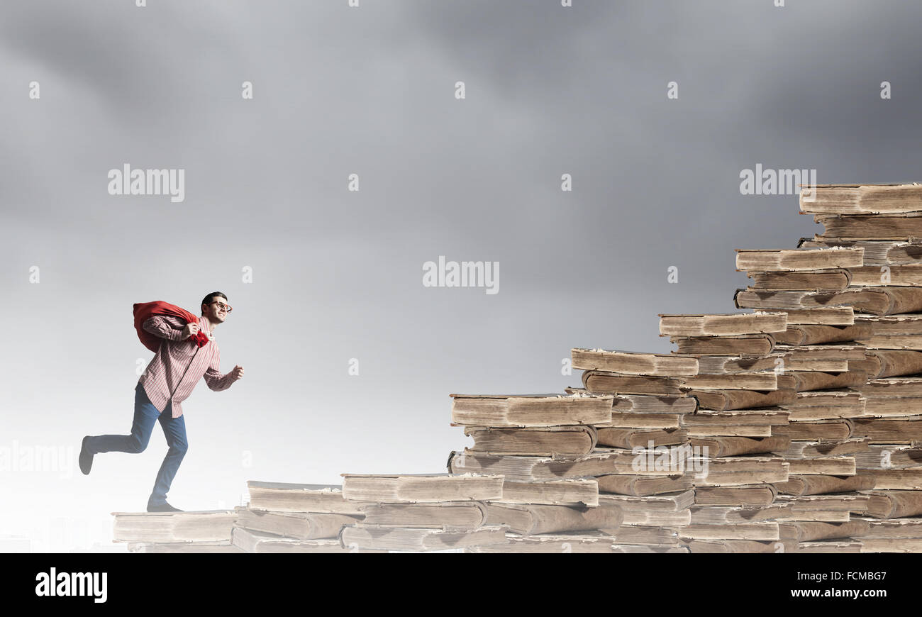 Young man in casual carrying heavy red bag Stock Photo - Alamy
