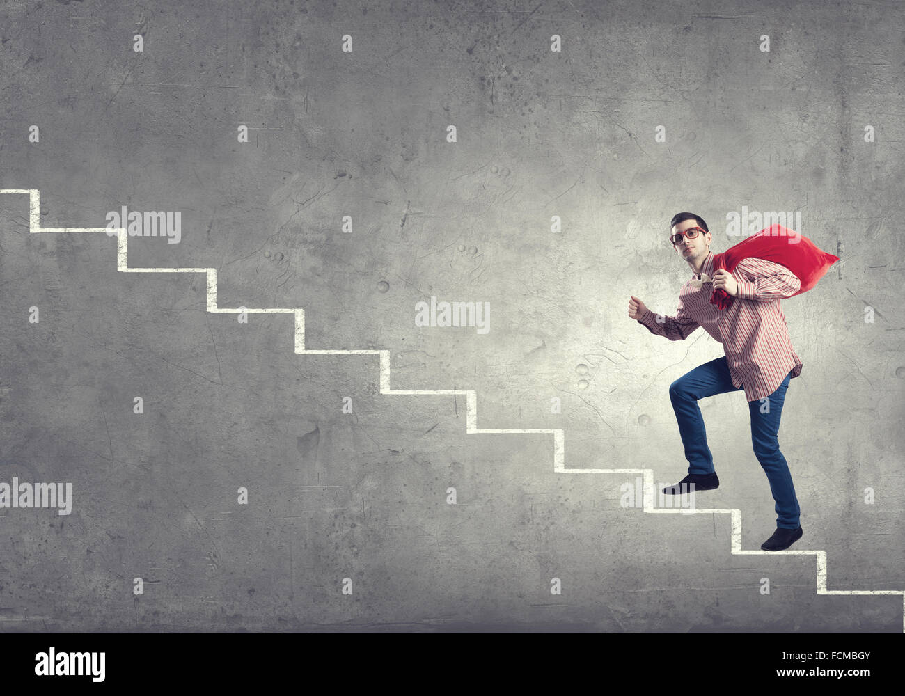 Young man in casual carrying heavy red bag Stock Photo - Alamy