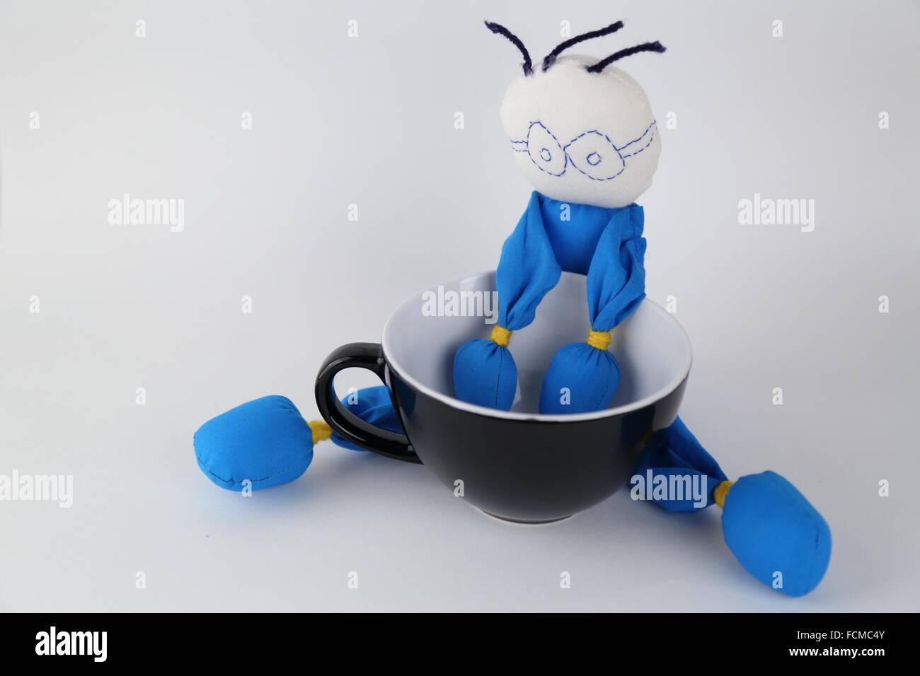 Puppet with its hands inside a bowl looking down Stock Photo - Alamy