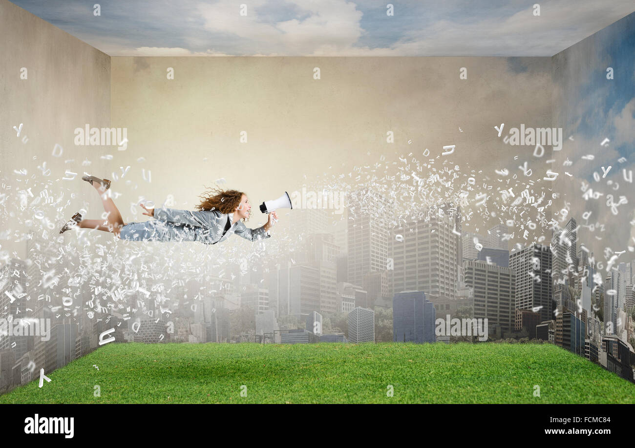Young woman with megaphone flying in sky and announcing something Stock ...