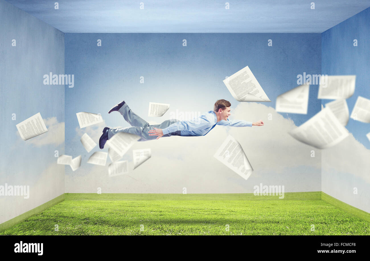 Young man flying in sky among flying around papers Stock Photo - Alamy