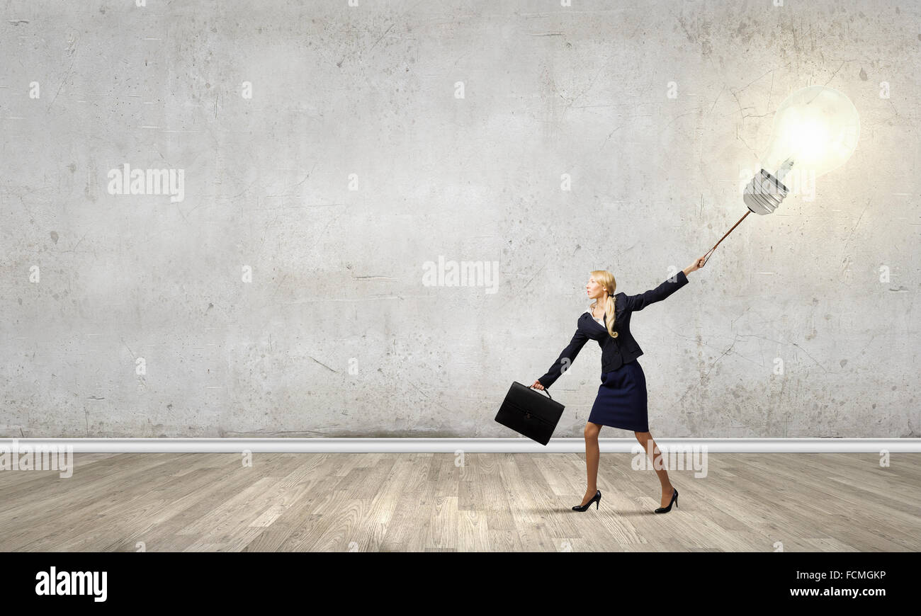 Young businesswoman pulling light bulb on rope Stock Photo - Alamy