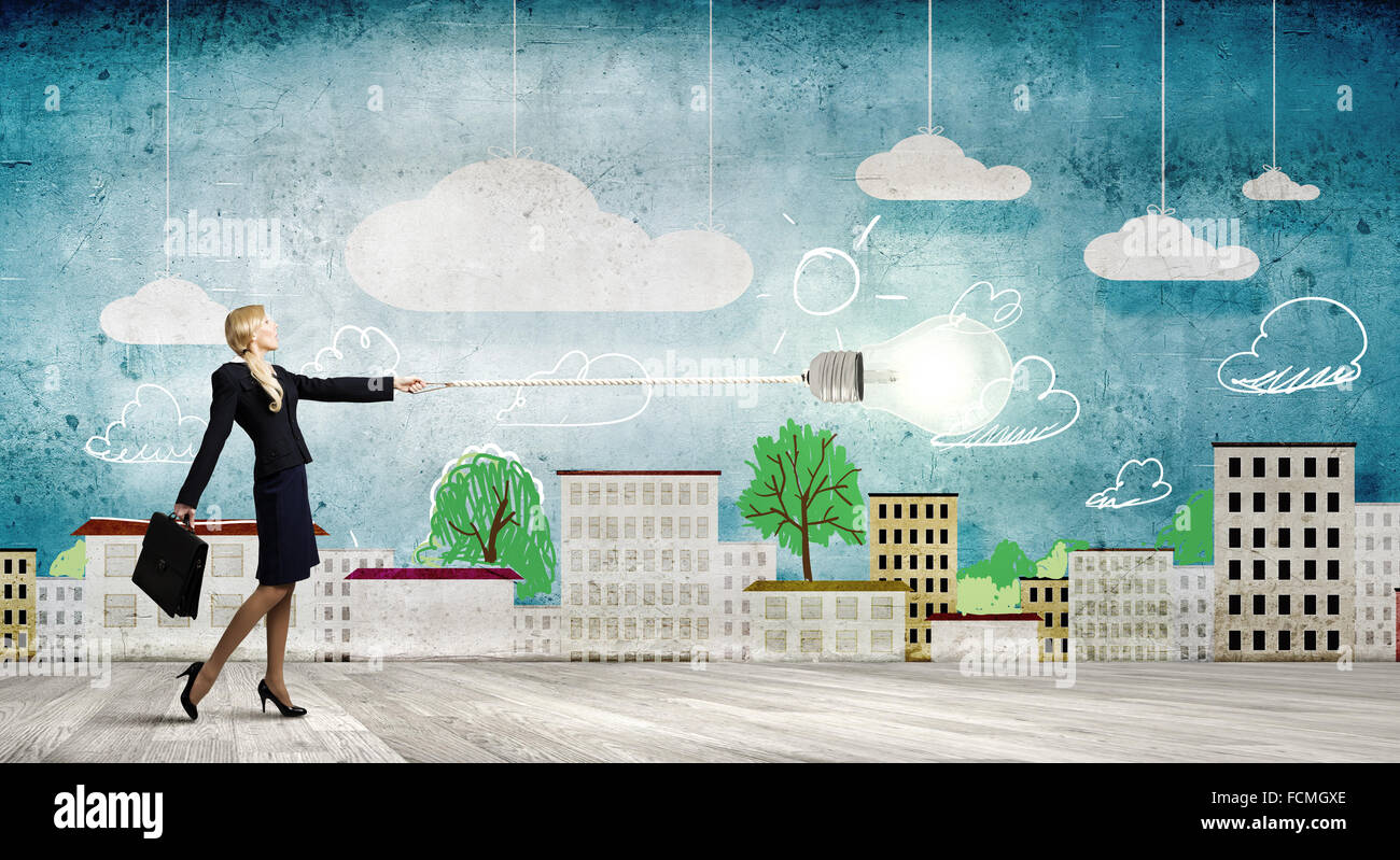 Young businesswoman pulling light bulb on rope Stock Photo - Alamy